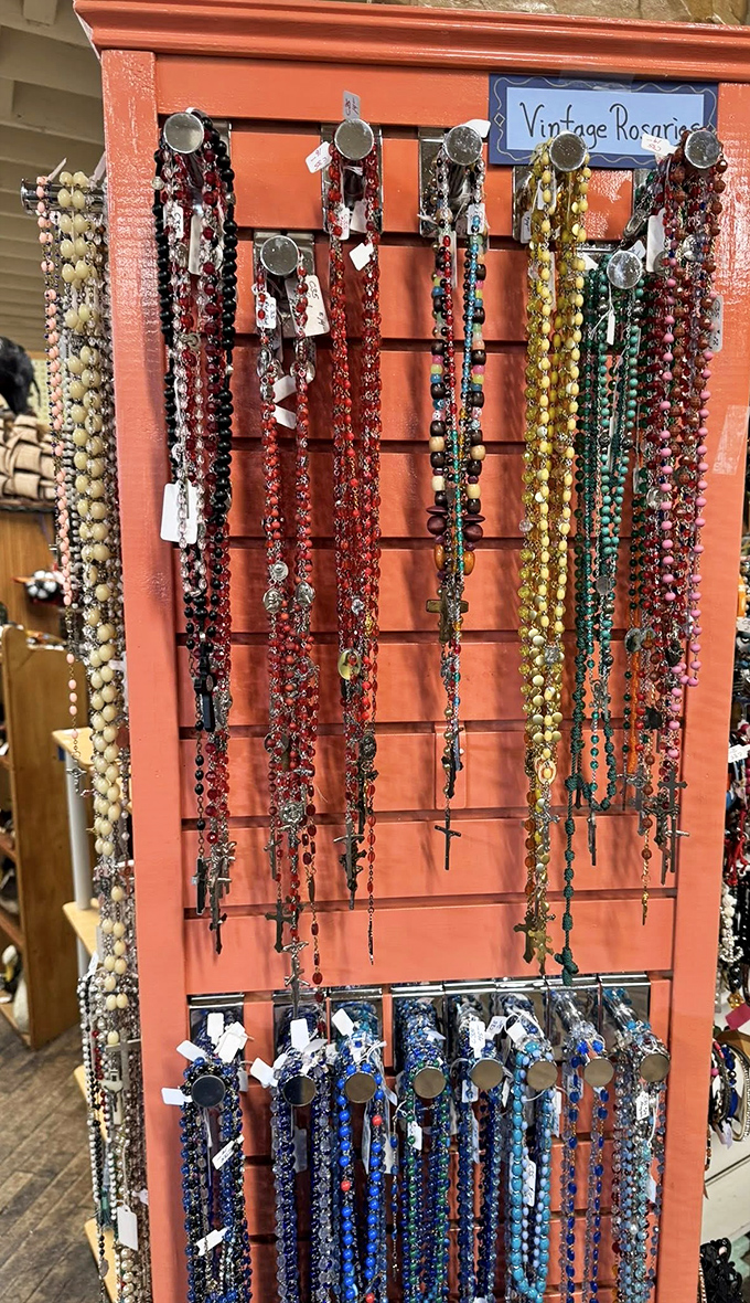 Vintage rosaries displayed like sacred jewelry, each bead carrying prayers and history. Faith and craftsmanship intertwined on a coral backdrop.