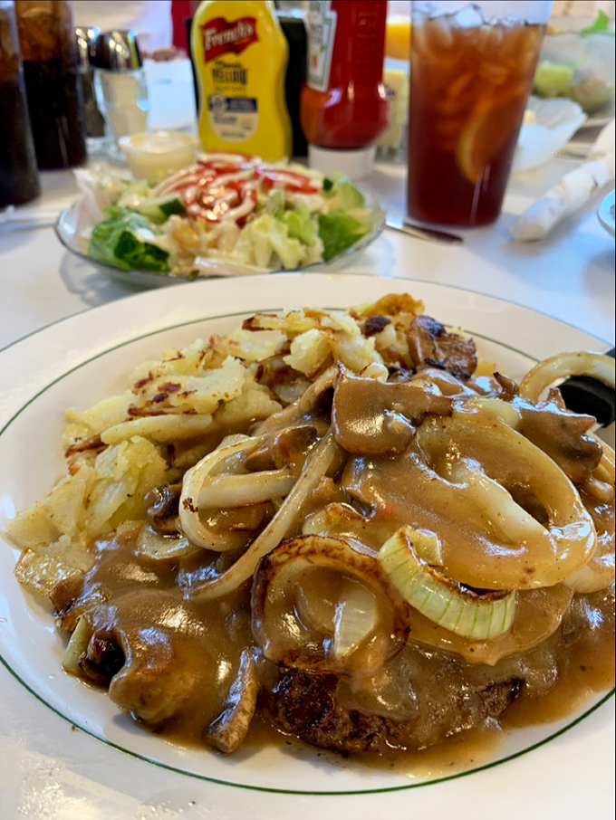 Salisbury steak swimming in a sea of savory gravy and caramelized onions. The kind of meal that makes you want to write thank-you notes to cows.