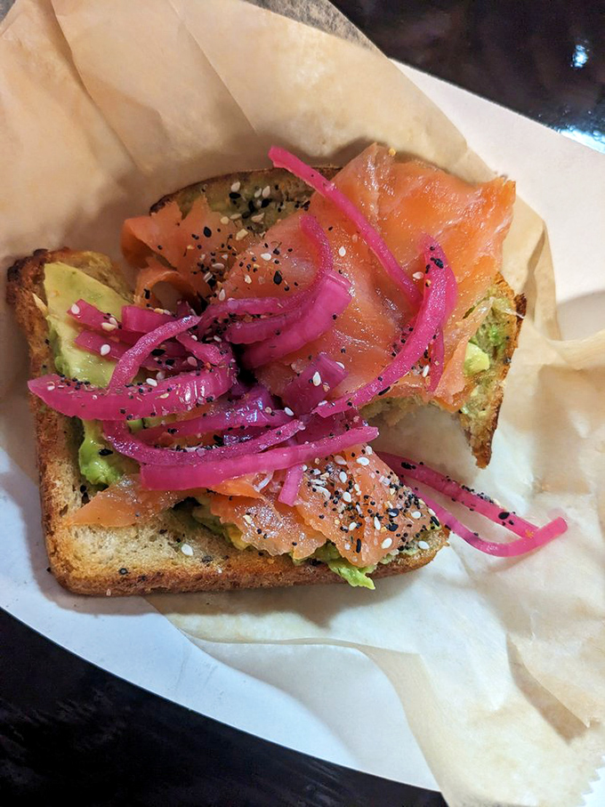 Smoked salmon and avocado toast with pickled red onions—proof that sometimes the best things in life are pink, green, and absolutely worth the splurge.