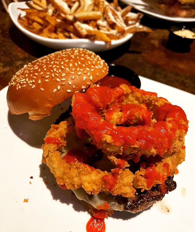 The architecture of deliciousness &ndash; crispy, spicy onion rings perched atop a perfectly seared patty. This burger doesn't just satisfy hunger; it conquers it.