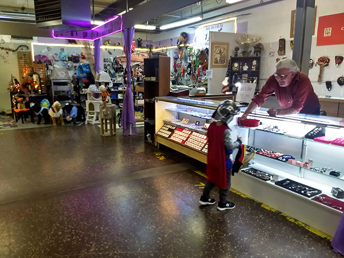 A vendor tends to a display case of treasures. These personal interactions add warmth to the shopping experience that no online marketplace can match.