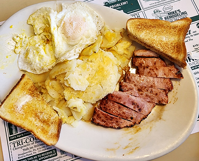 Breakfast of champions: eggs sunny-side up, home fries with personality, and ham sliced thick enough to make a vegetarian reconsider their life choices.