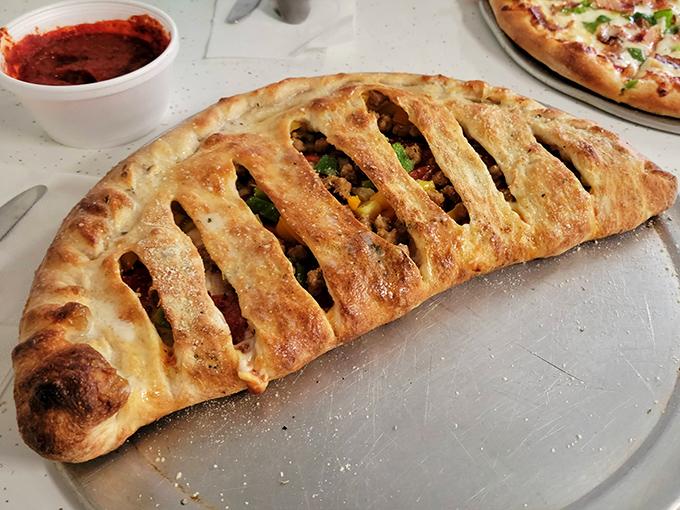 The stromboli arrives like an edible treasure chest, its golden-brown lattice crust barely containing the savory riches within. Worth every delicious calorie.