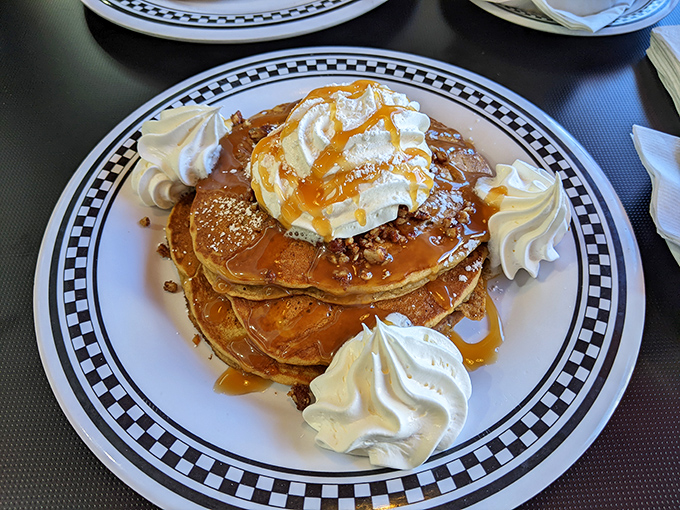 These pancakes aren't just stacked&mdash;they're architectural marvels topped with whipped cream islands in a sea of maple syrup.