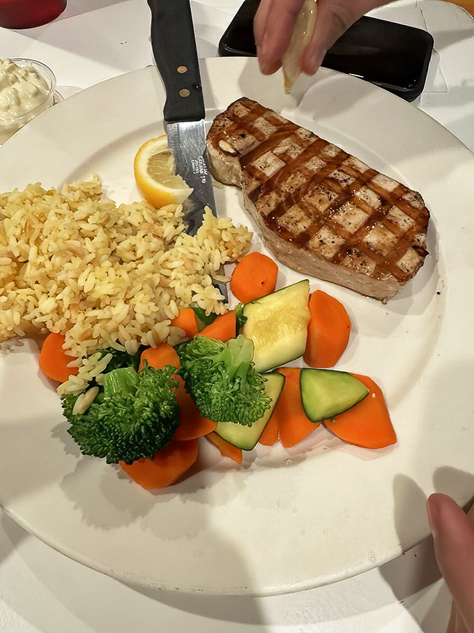 Perfectly grilled swordfish with grill marks that deserve their own art exhibition. The rice and vegetables aren't sides &ndash; they're supporting actors in a delicious ocean drama.