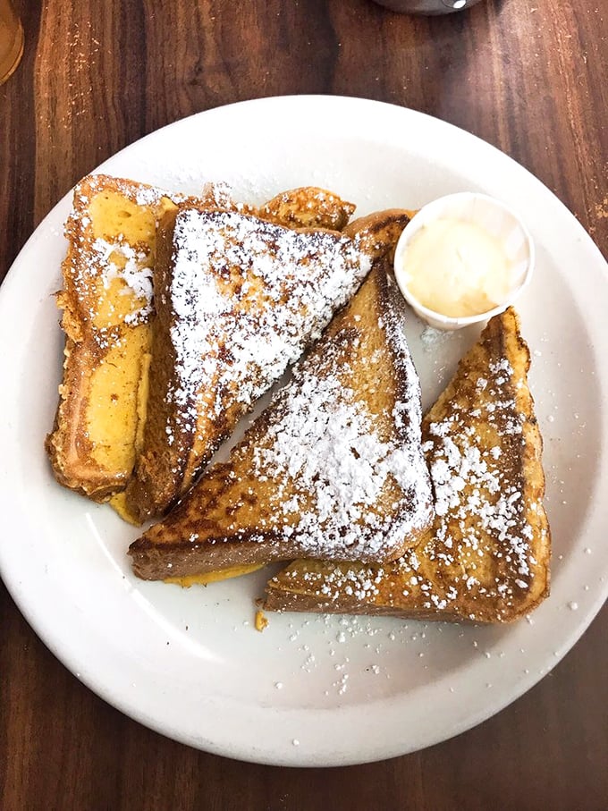 French toast dusted with powdered sugar, thick-cut and griddled to perfection, proving simple ingredients done right beat fancy every time.