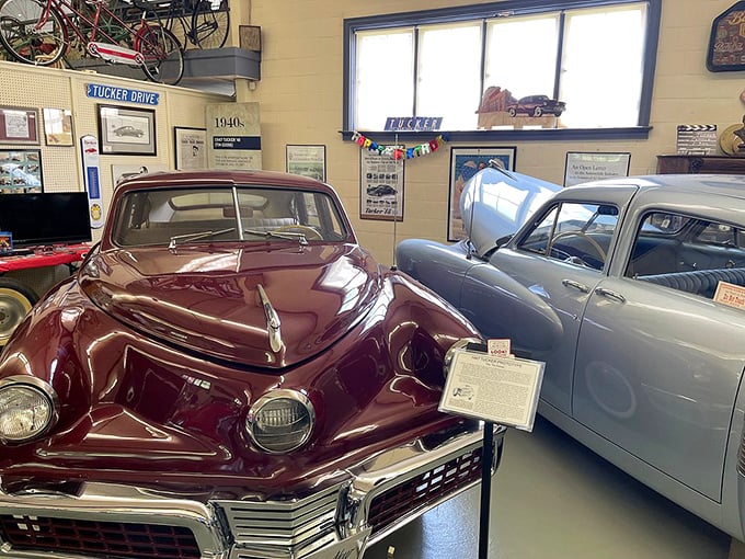 The legendary Tucker 48 sits in burgundy splendor, its third center headlight a reminder of innovation that was perhaps too revolutionary for its time.