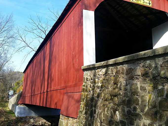 The weathered stone abutments and vibrant red siding create a textural contrast that architects and photographers find equally mesmerizing.