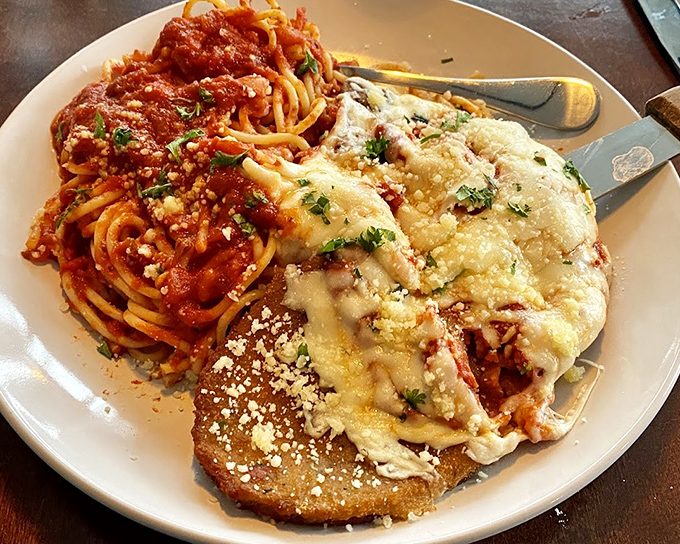 Veal Parmesan and spaghetti sharing a plate like old friends, the melted cheese blanket making everything underneath taste like a warm hug.