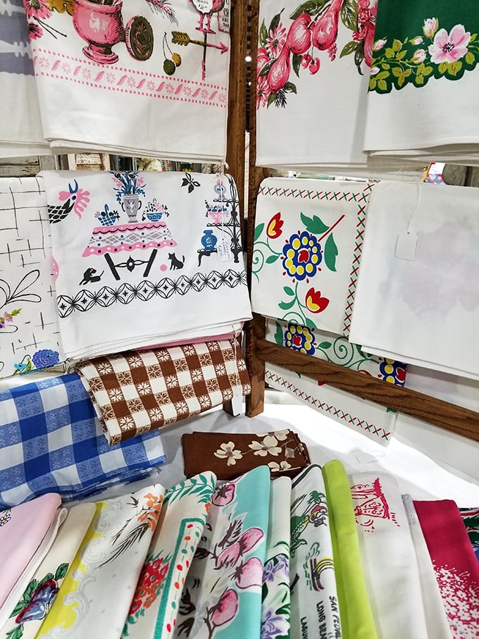 Vintage tea towels hang like textile time capsules, each pattern telling stories of kitchens long ago.