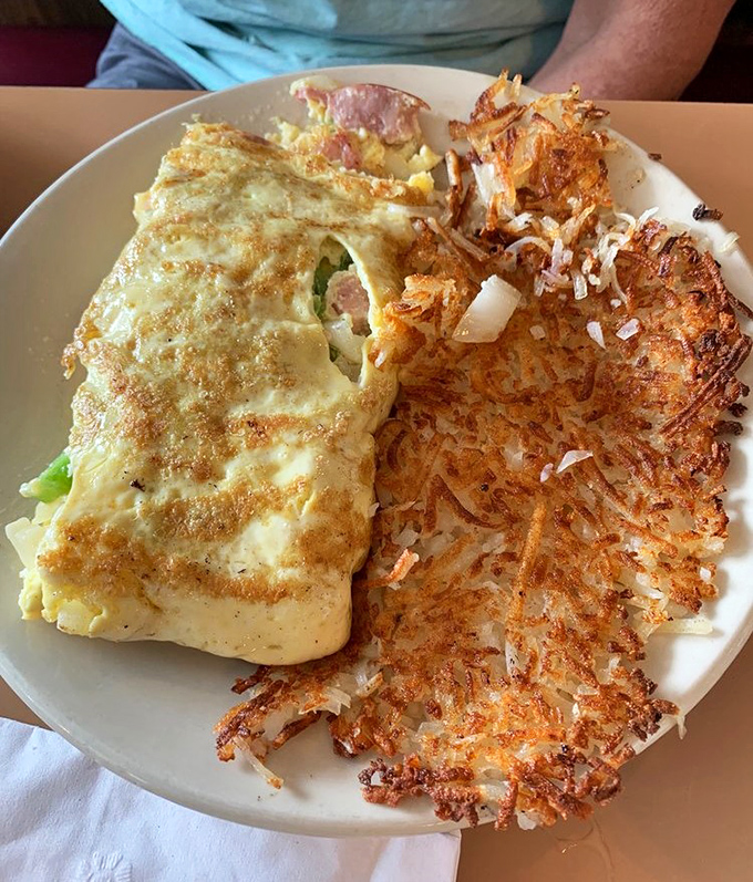 The Western omelet and hash browns create a breakfast symphony on the plate. Notice how the crispy edges of both create textural magic.