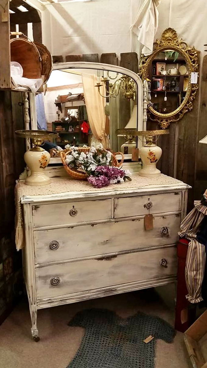 That distressed white dresser with ornate mirrors proves shabby chic was doing its thing long before Pinterest existed.