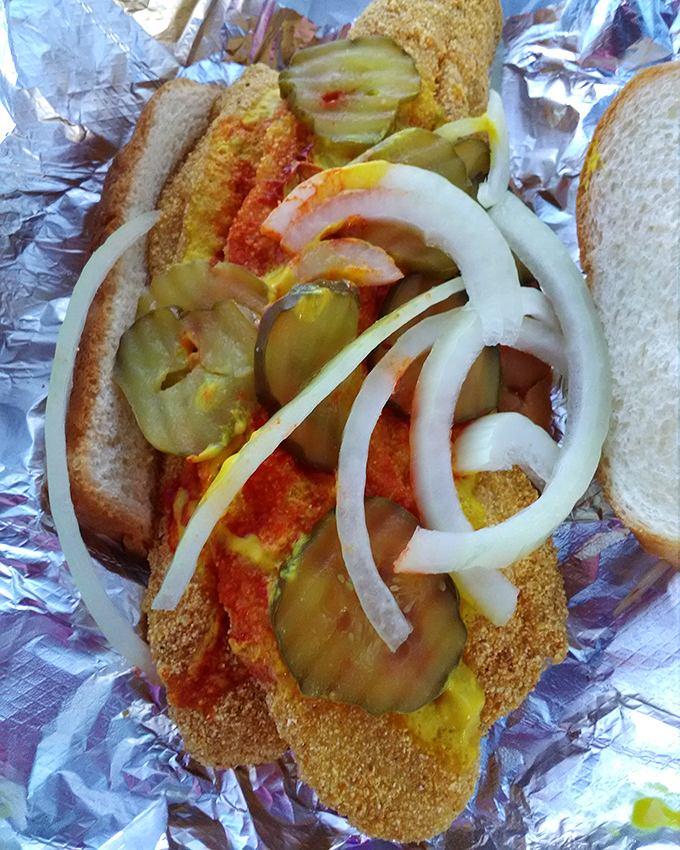 The Nashville combination in all its glory&mdash;crispy fish, mustard, hot sauce, pickles, and onions creating a symphony of flavors between humble bread.