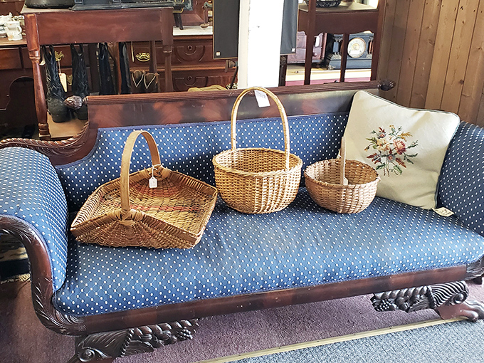 A blue Victorian fainting couch displays handwoven baskets that once carried picnics, groceries, and secrets from a simpler time.