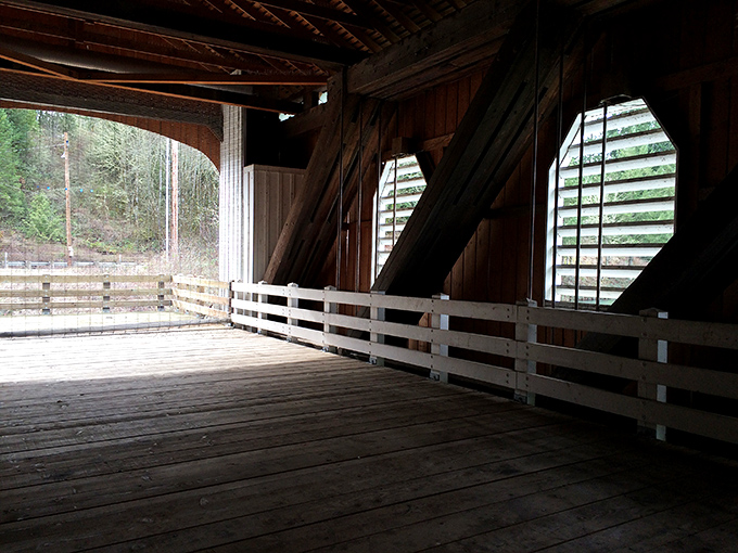 Those octagonal windows aren't just for show—they're the bridge's eyes, watching decades of travelers pass through while letting in dappled light that dances across the planks.