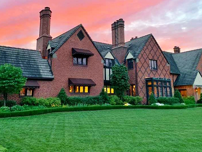 As sunset bathes this Tudor-style mansion in golden light, you can almost hear the stories whispering from behind those leaded glass windows.