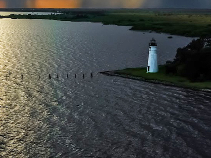 Bird's eye magic! The lighthouse stands on its slender peninsula, surrounded by the gentle embrace of water on three sides.