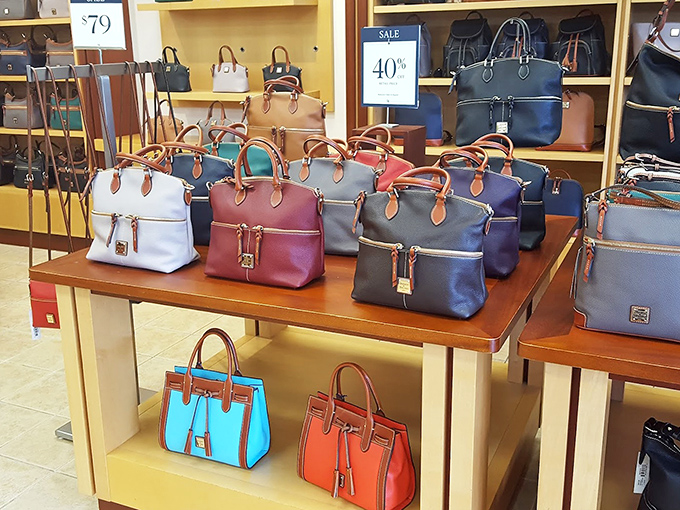 A rainbow of designer handbags stands at attention, each one whispering, "I'm 40% off and would look fabulous with everything you own."