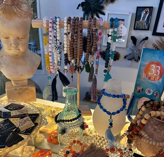 Beaded bracelets displayed like colorful candy, draped over vintage busts and bottles. Wearable art with previous lives, waiting for new wrists.