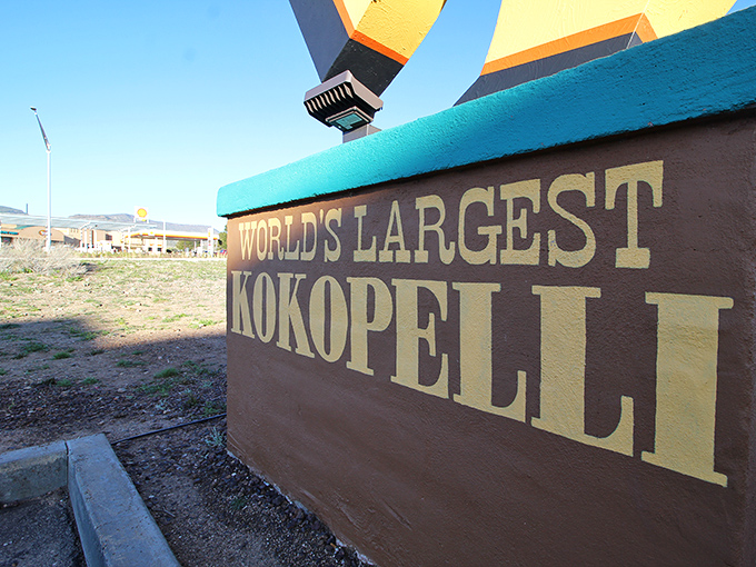 The base proudly proclaims its world record status—because if you're going to build a giant flute-playing fertility deity, why not make it the biggest?