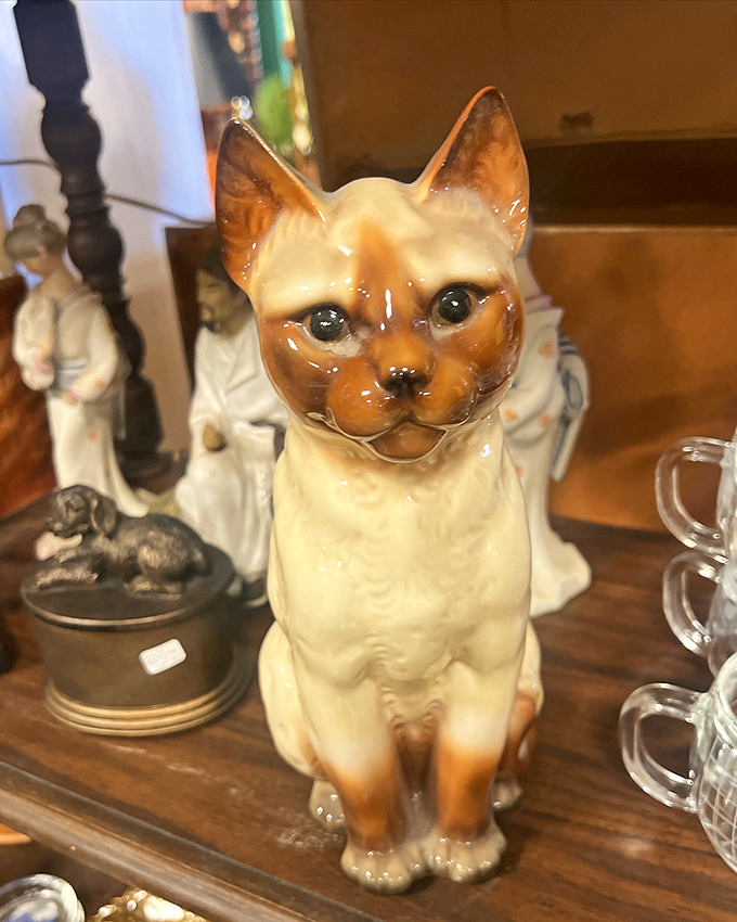 This Siamese cat figurine has been judging people's decorating choices since before you were born, and it's not stopping now.