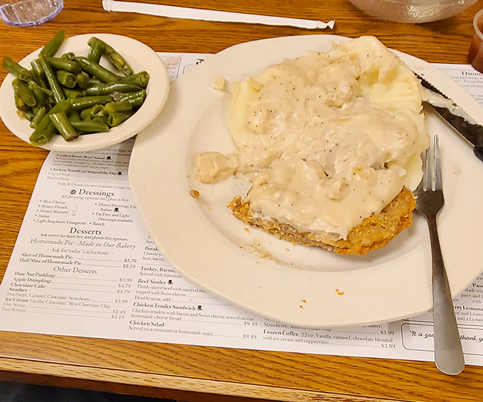 Country fried steak smothered in gravy with green beans and mashed potatoes&mdash;the holy trinity of comfort that makes Monday feel like Sunday.