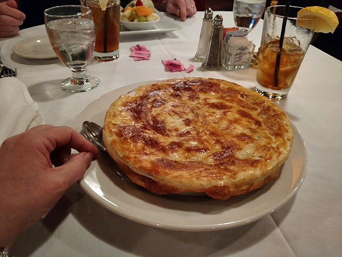 The chicken pot pie arrives like a golden-domed cathedral of comfort, promising salvation from whatever ailed you when you walked in.