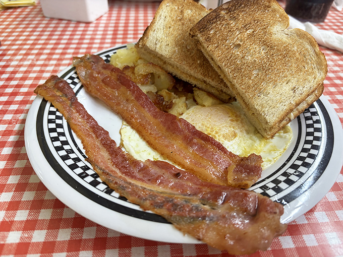 The holy trinity of breakfast: perfectly crisp bacon, sunny-side eggs, and toast that somehow manages to be both crispy and buttery. Simplicity at its finest. 