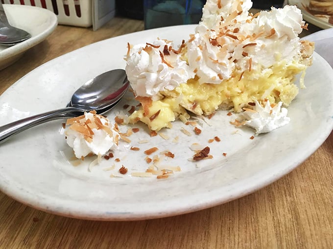 Coconut cream pie with a mountain of whipped cream and toasted coconut flakes. This isn't dessert&mdash;it's edible happiness with a fork.