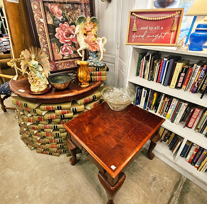 Books stacked on books with vintage figurines on top&mdash;this corner is like a time capsule of American decorative arts waiting to be discovered.