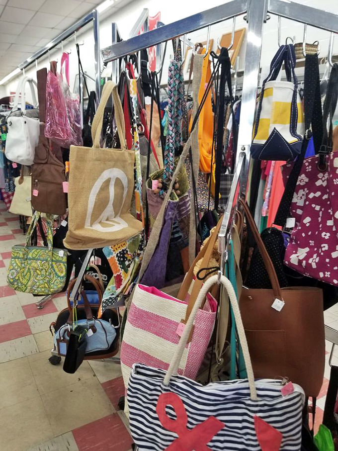 A rainbow of totes and handbags dangles with possibility—beach-ready stripes alongside sophisticated leather companions.