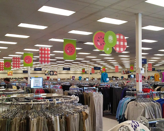 Watermelon-themed decorations hang cheerfully above the clothing department, proving that even thrift stores have seasonal flair.