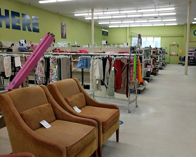 Mid-century modern chairs await their second act while clothing racks stand like soldiers guarding fashion from every era.