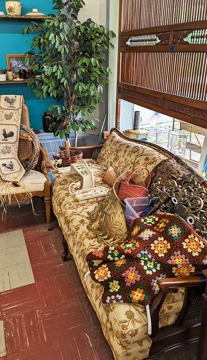 A pattern-rich sofa draped with a handmade afghan creates the kind of cozy corner that makes minimalists question their life choices.