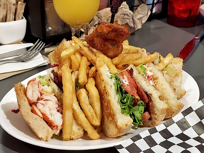 The lobster club sandwich&mdash;where seafood meets comfort food in perfect harmony. Those fries standing at attention know they're in good company.