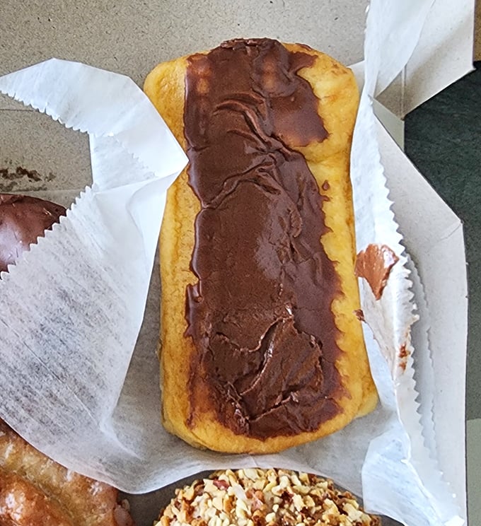 The long john&mdash;that magnificent torpedo of fried dough and chocolate&mdash;sitting pretty in its paper cradle. Some food affairs are worth the commitment.