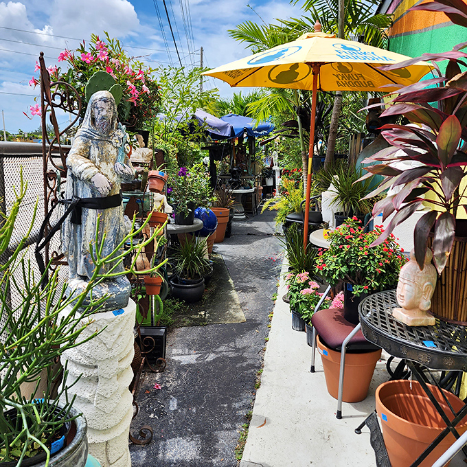 Religious statues, colorful umbrellas, and potted plants create an unexpectedly charming outdoor browsing experience worth exploring.