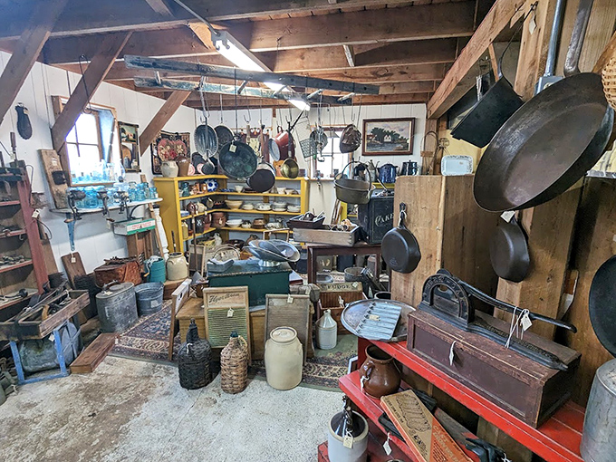 Cast iron paradise where skillets hang like battle-tested warriors, ready for their next culinary campaign in someone's farmhouse kitchen.