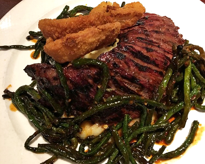 The skirt steak, sliced to perfection and nestled on a bed of vibrant greens, proves that sometimes the simplest preparations yield the most spectacular results.