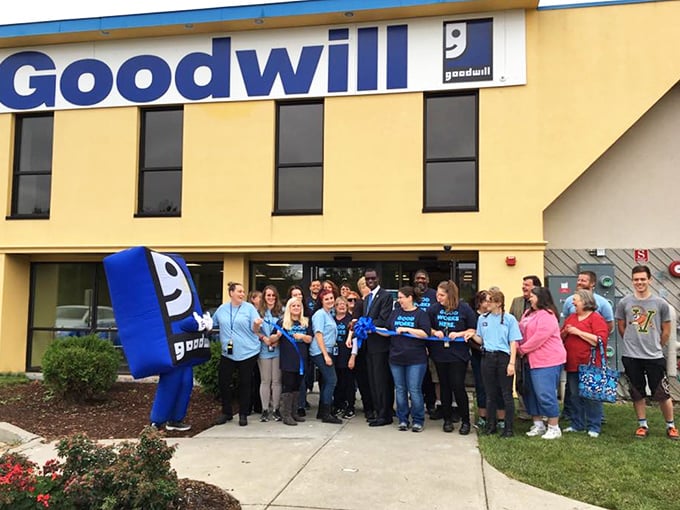 The team that transforms donations into retail magic, standing proudly outside their blue-trimmed kingdom of second chances.