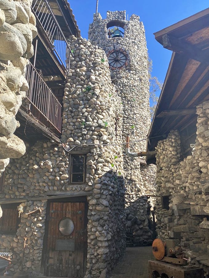 Sunlight plays between towers of river rock and embedded bottles, creating a cathedral-like atmosphere in this handcrafted fortress &ndash; DIY castle-building at its finest.