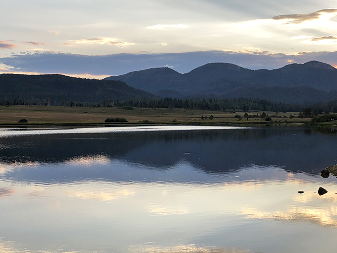 Sunset transforms Steamboat Lake into a painter's palette of purples and blues, the mountains silhouetted like sleeping giants against the twilight sky.