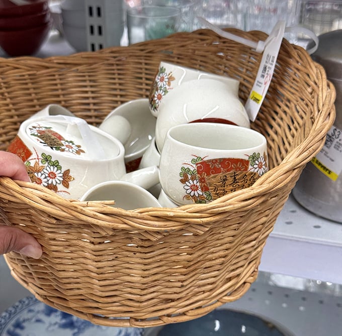 Delicate teacups nestled in their basket home, waiting for their next tea party. Floral patterns that whisper stories of gatherings past.