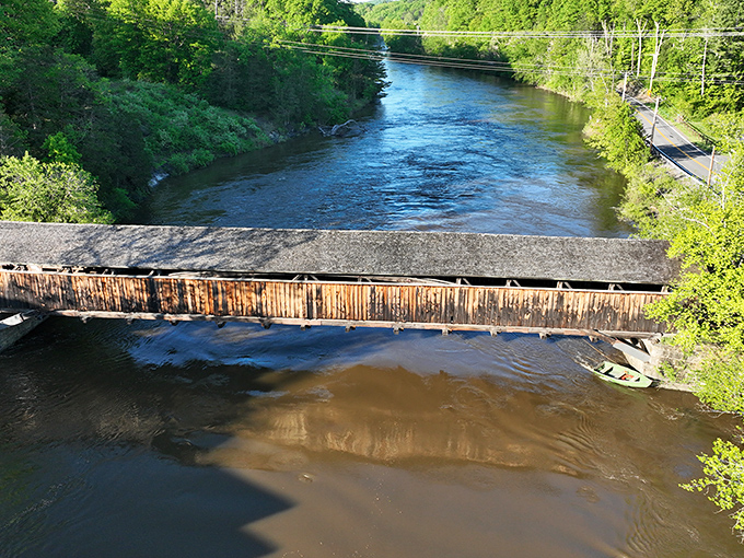 From above, the bridge cuts a striking silhouette against the water, like a wooden brushstroke on nature's canvas.