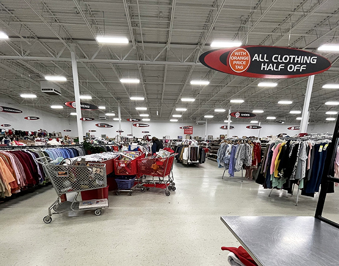 The "orange tag half off" sign hovers like a benevolent retail deity over shoppers navigating carts through the thrifting promised land.