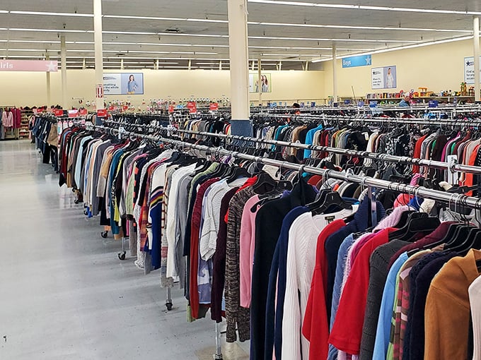 Row after meticulous row of women's clothing creates a kaleidoscope of possibilities. Each hanger holds potential transformation at fraction-of-retail prices.