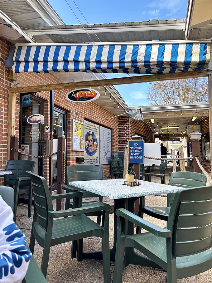 Arena's blue-striped awnings flutter in the sea breeze, promising sandwich salvation for beach-weary visitors. A coastal oasis for the seriously hungry.