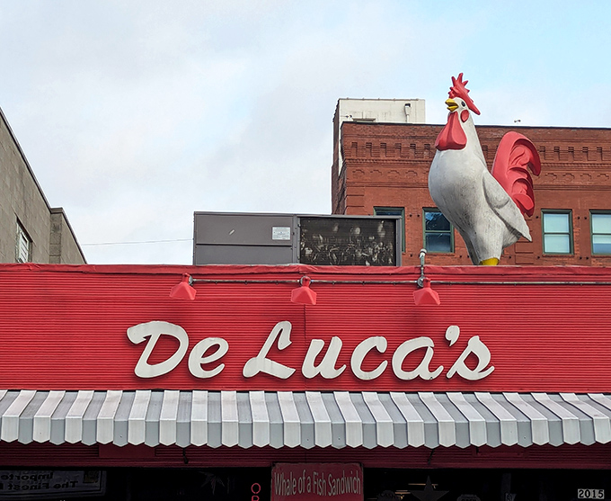 That giant rooster isn't just showing off – it's crowing about the legendary breakfast waiting inside DeLuca's red storefront.