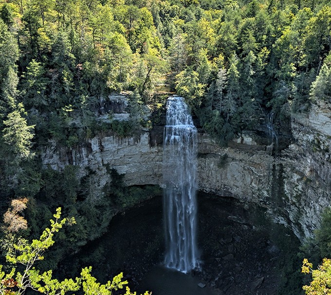 A breathtaking waterfall plunges dramatically into a limestone basin, nature's version of the grand finale in a spectacular show.
