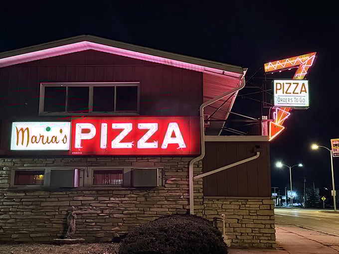 Maria's neon sign glows like a pizza lighthouse in the night. That arrow points to flavor heaven!